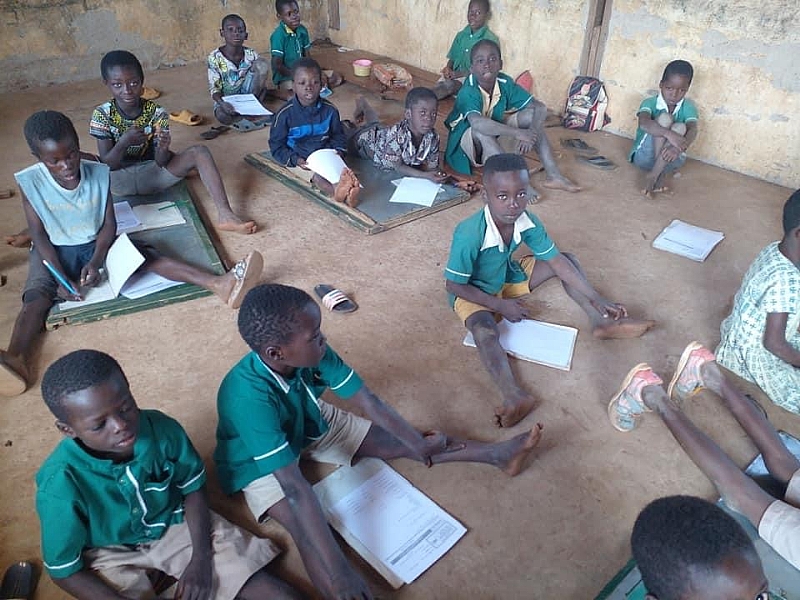 Pupils of Eggu R/C Primary School lie on bare floor to study, write exams