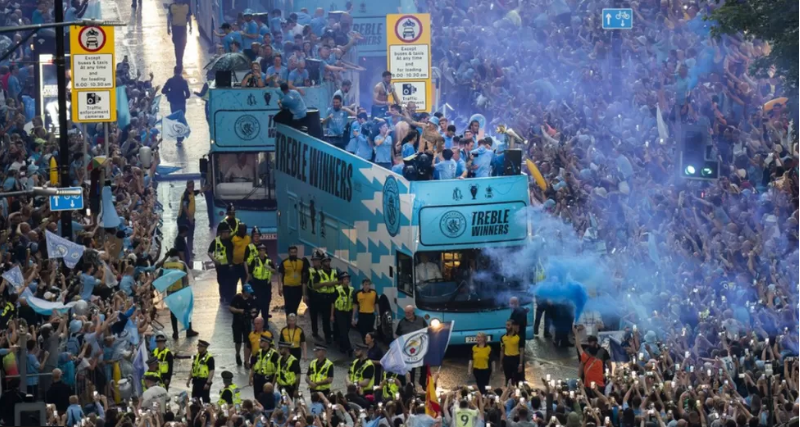 Manchester City fans and players celebrate historic Treble in the rain